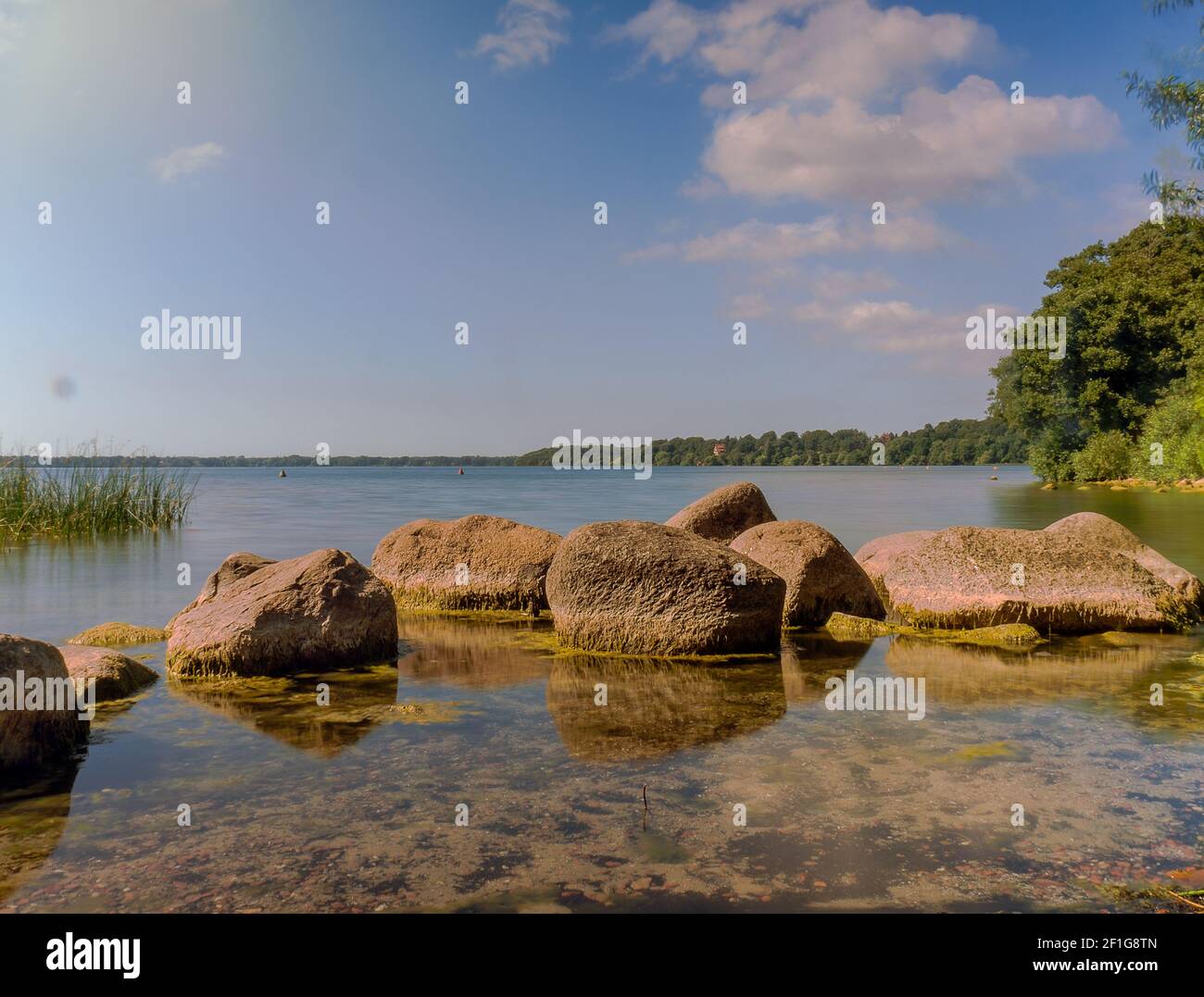 A scenic view of rocks on the lakeside in Virum, Denmark under a cloudy ...