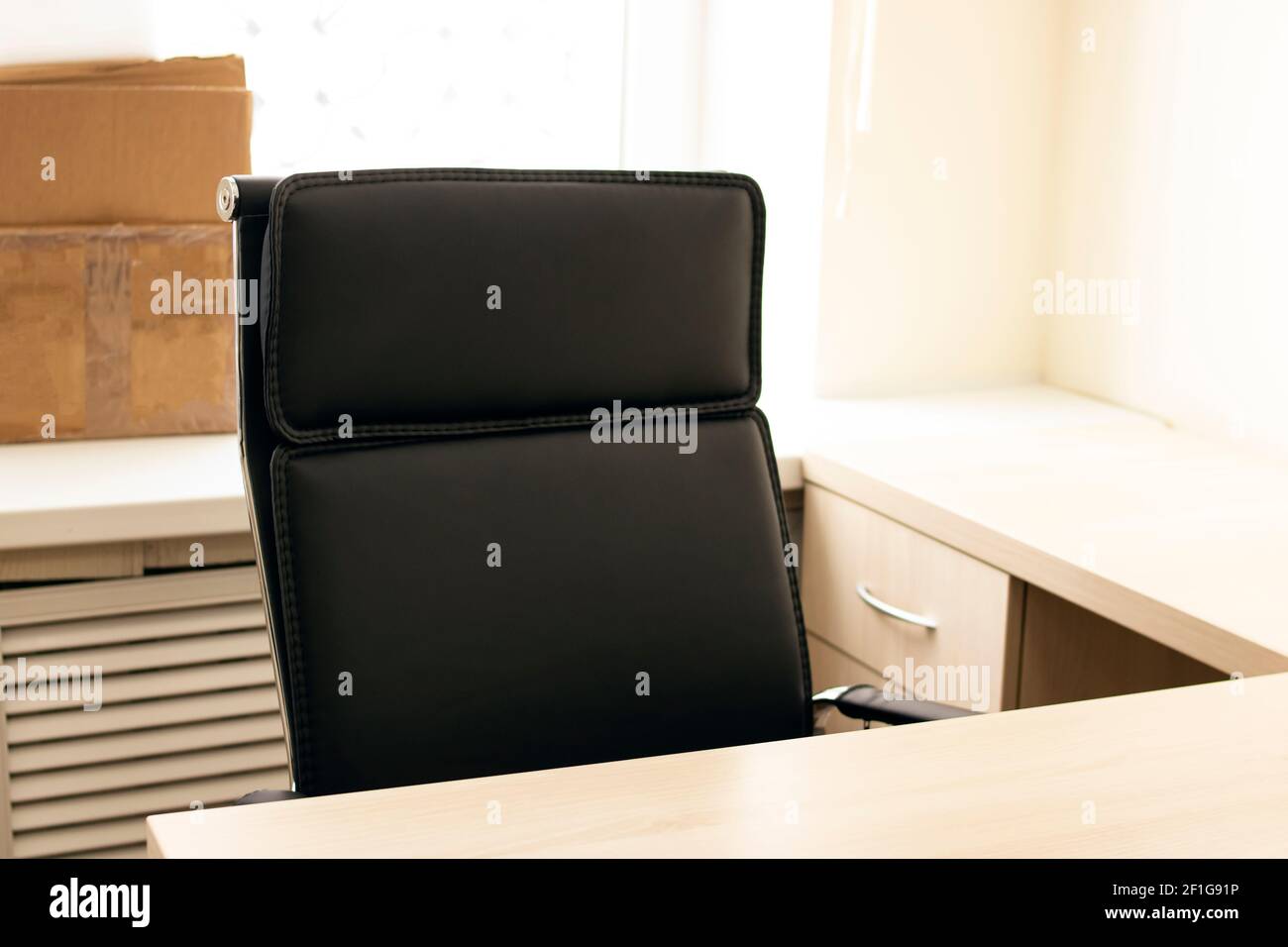 Wooden table and black office chair close up Stock Photo - Alamy