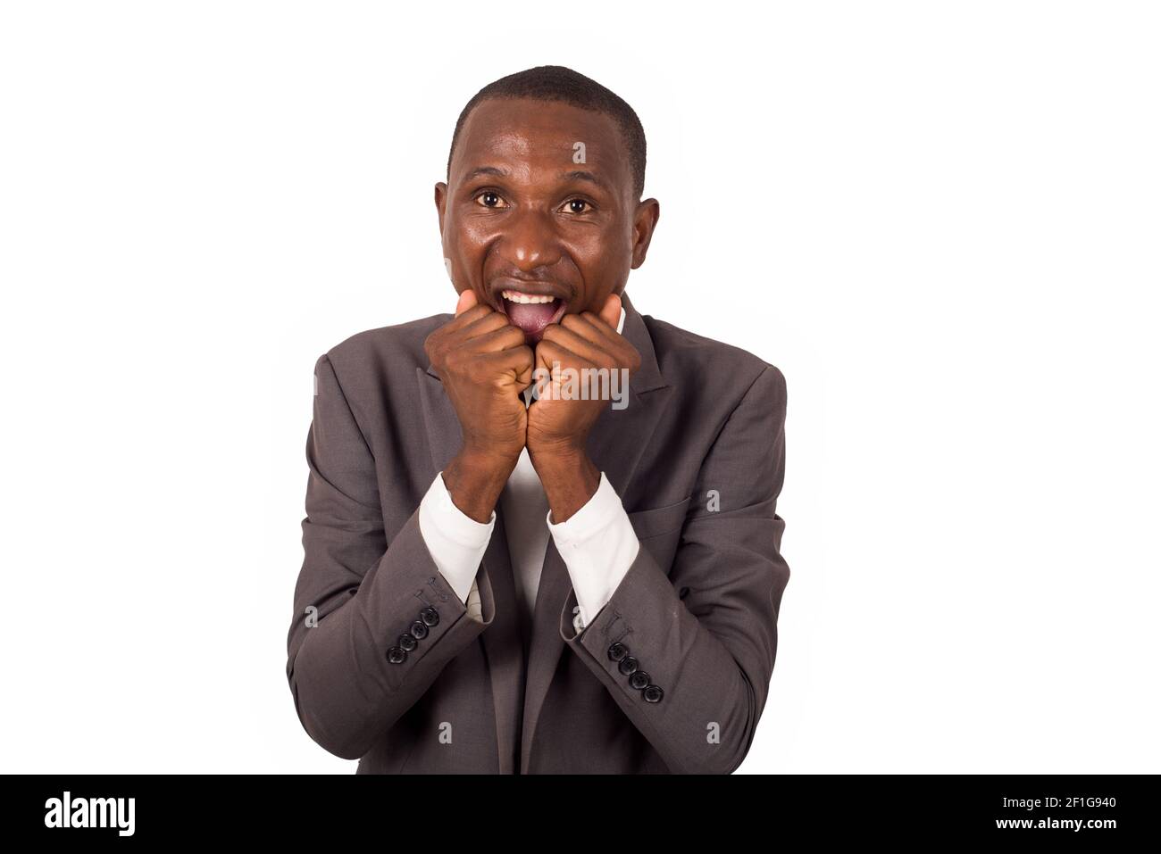 portrait of young man in suit standing and biting his fingers isolated ...