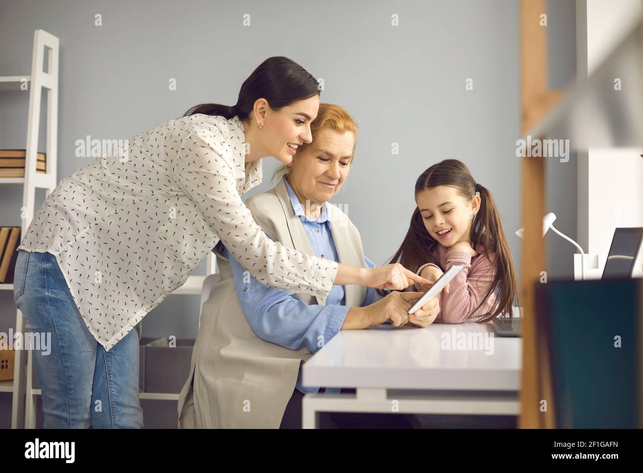 Happy family teaching their grandmother to download app on modern ...