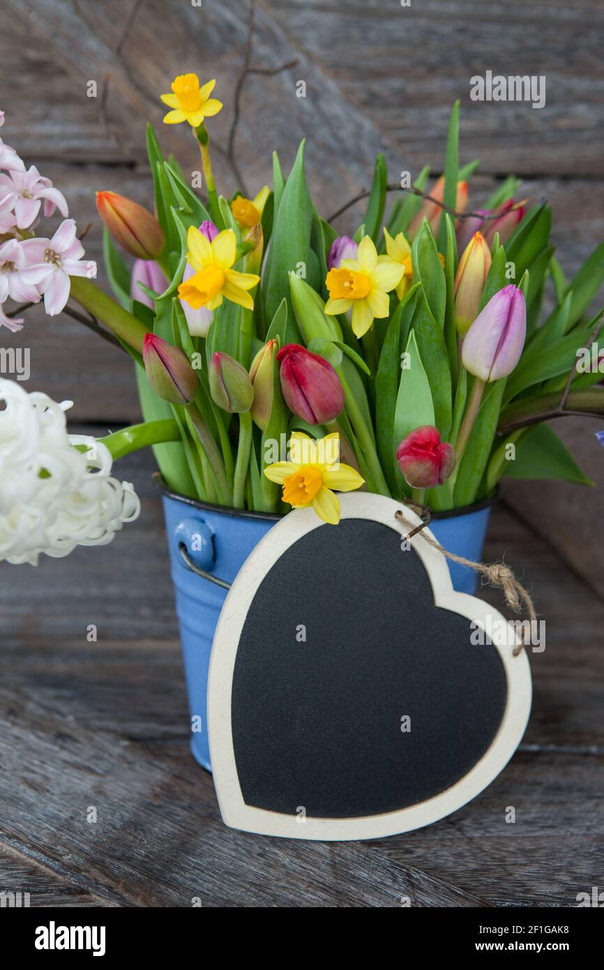 Colorful spring flowers in rustic bucket Stock Photo - Alamy