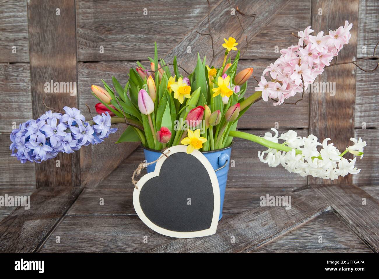 Colorful spring flowers in rustic bucket Stock Photo - Alamy