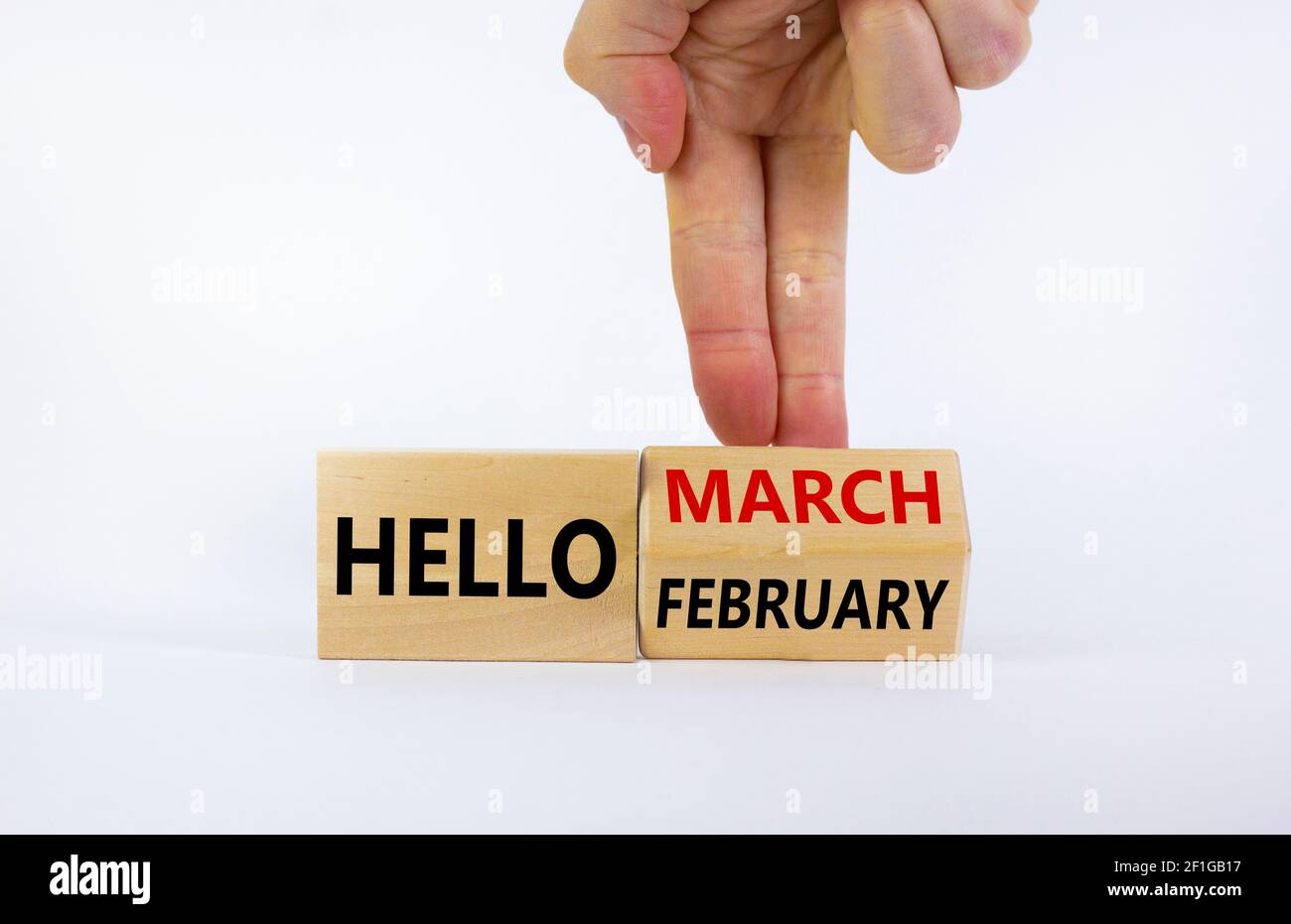 Symbol for the change from February to March. Businessman turns wooden ...