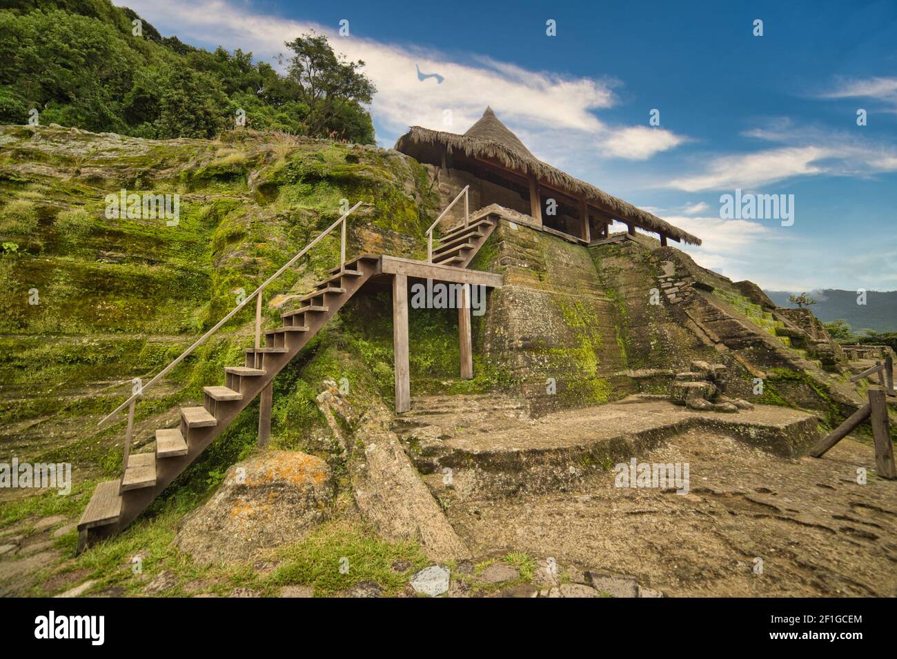 A side view of a hand-carved pyramid placed at the top of a mountain in ...