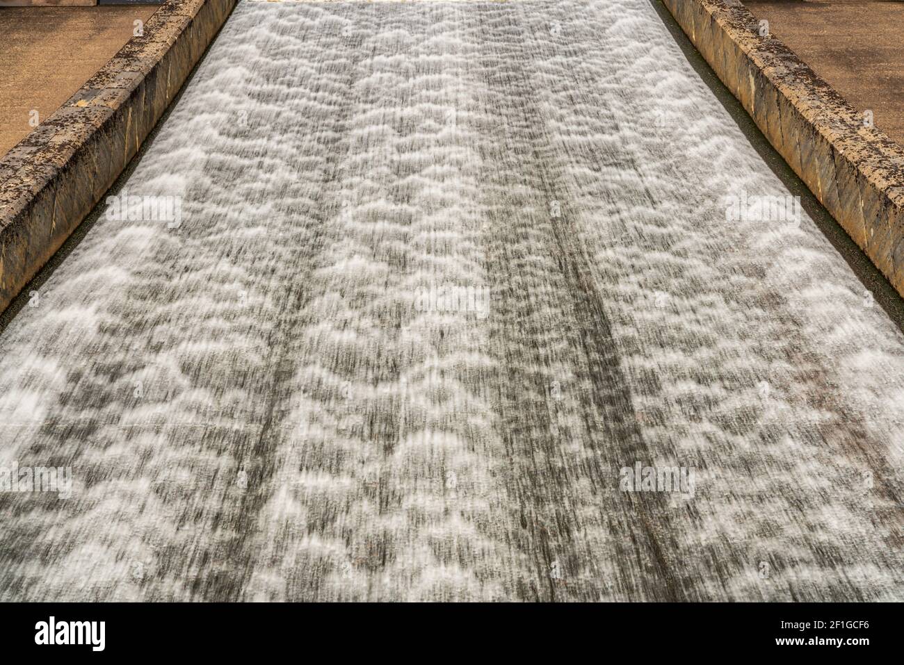 Water flowing down the dam of a reservoir Stock Photo - Alamy