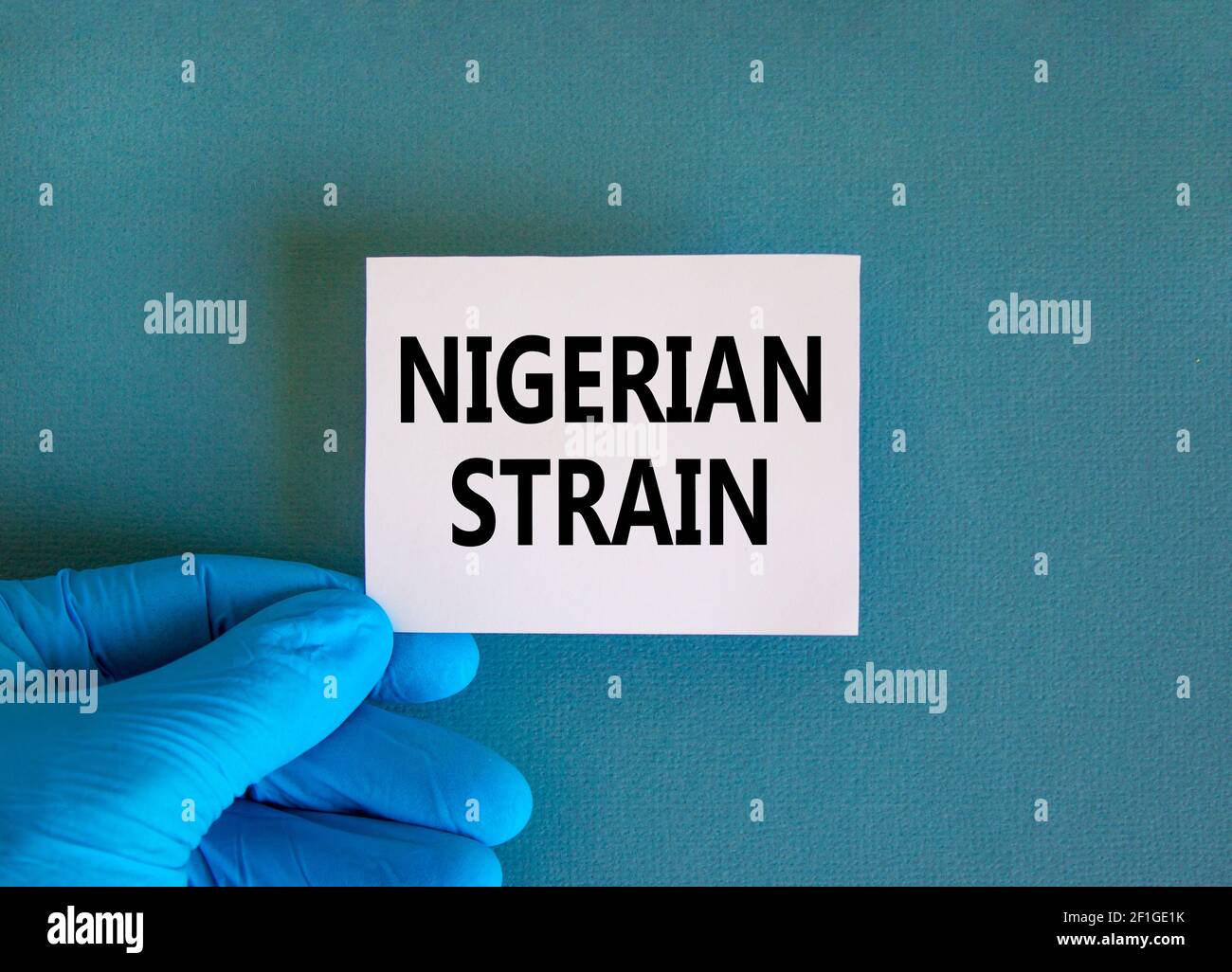 New covid-19 nigerian strain symbol. Hand in blue glove with white card ...