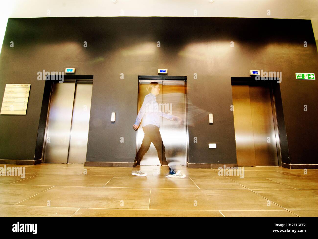 Woman Running Past Elevator Stock Photo - Alamy