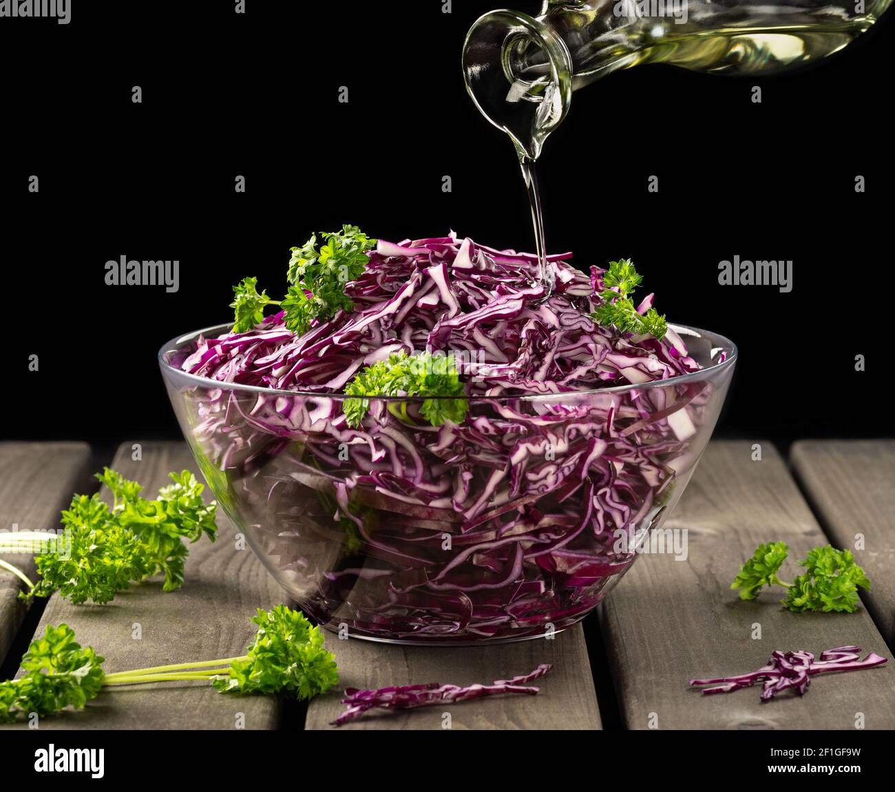 Vegan concept, healthy eating. red cabbage salad is poured with olive ...