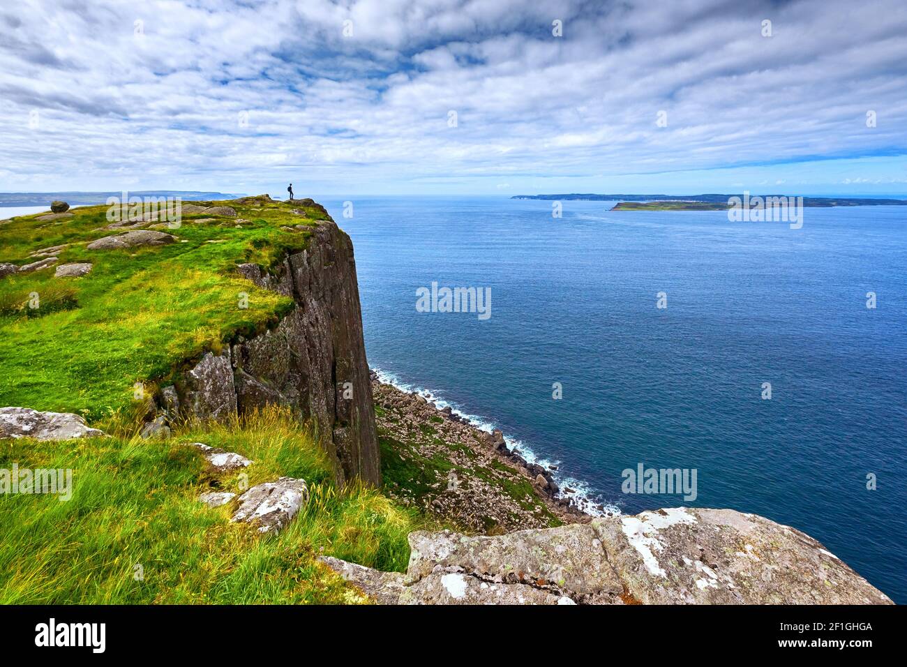 tourist with backpack standing on the cliff Fair Head, Northern Ireland ...