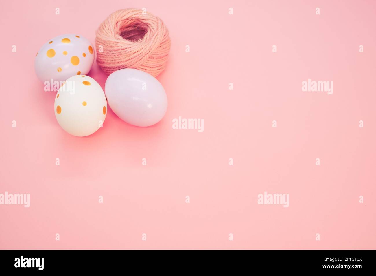 Decorated eggs and a thread isolated on pink background Stock Photo - Alamy