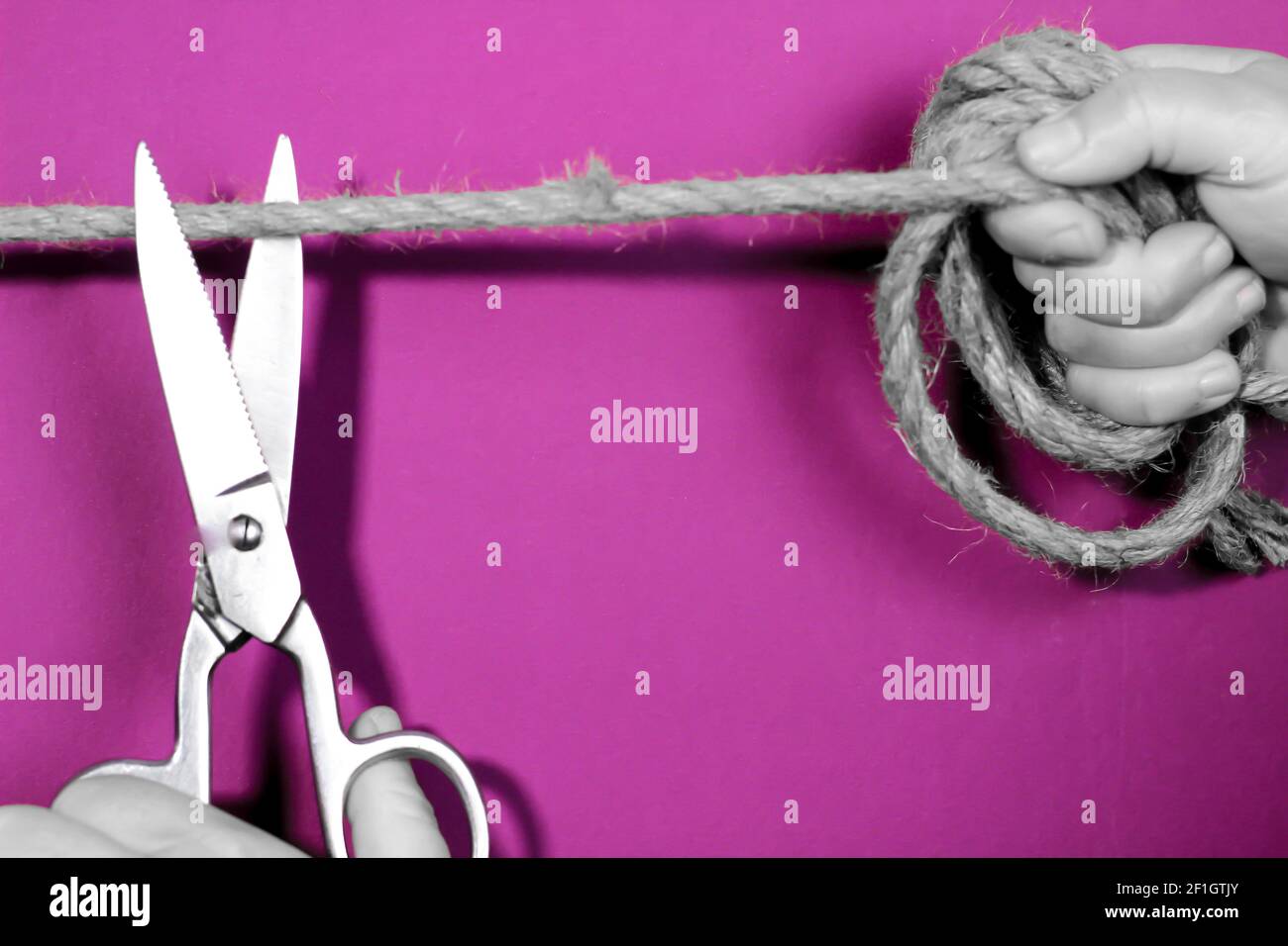 Hand wit scissors cutting rope symbolizing the lack of freedom of women ...