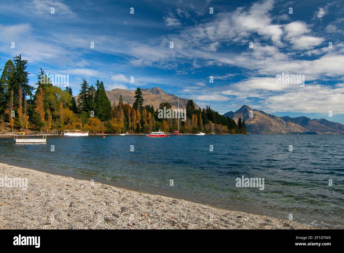 Autumn season at Queenstown Bay Beach, boats at Lake Wakatipu, colorful ...