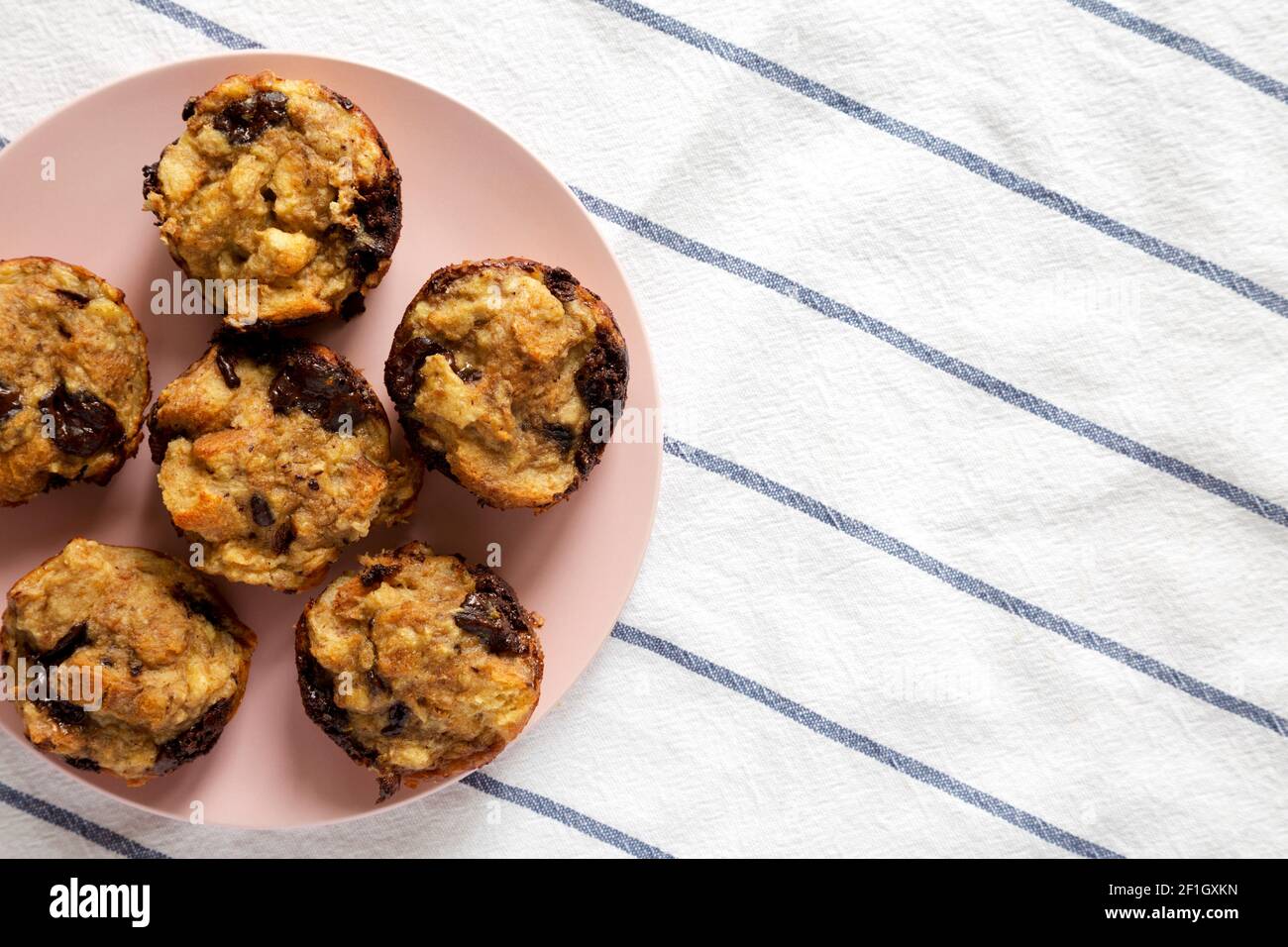 Homemade Chocolate Banana Bread Pudding on a pink plate, top view. Flat ...