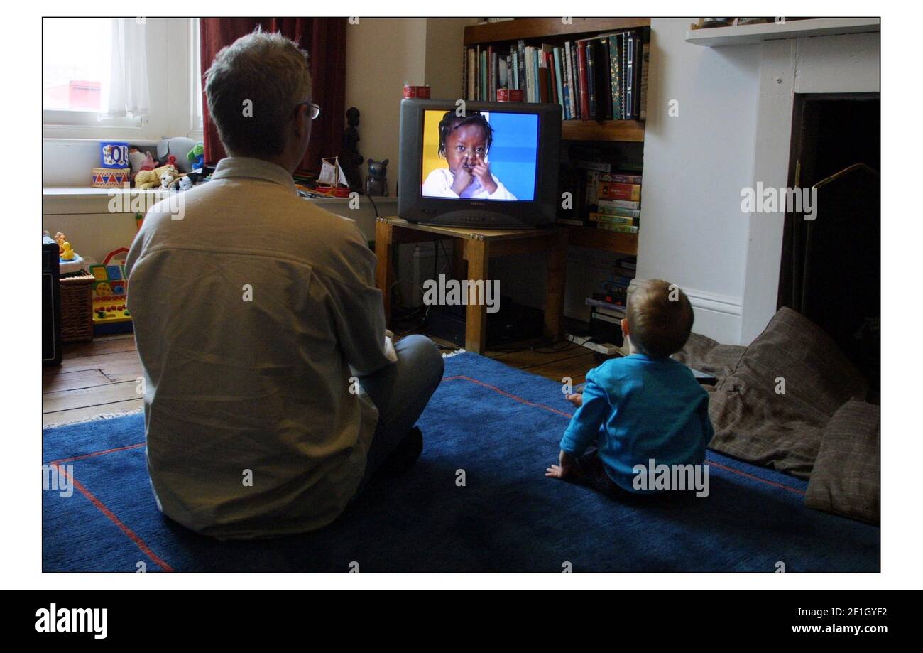 Oliver Bennett watching Tv with his son Bruno.pic David Sandison 30/10 ...