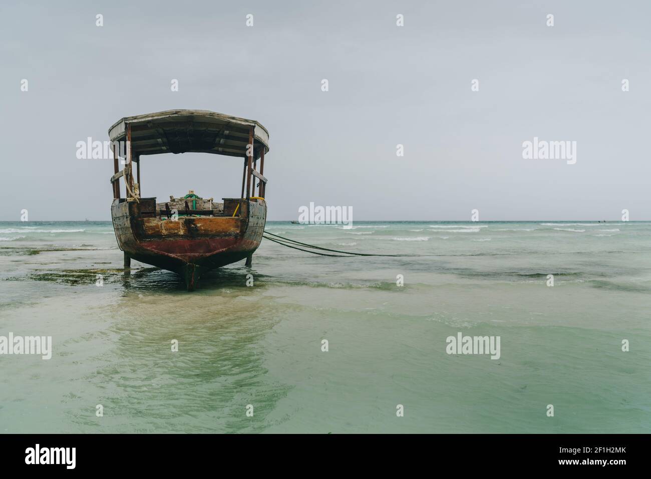 Shallow atoll sandbanks with lonely fisherman boat on low tide Nungwi ...