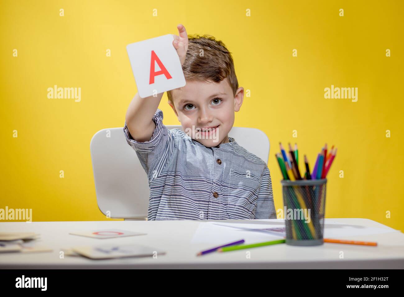 Happy smiling little preschool boy shows letters at home making ...