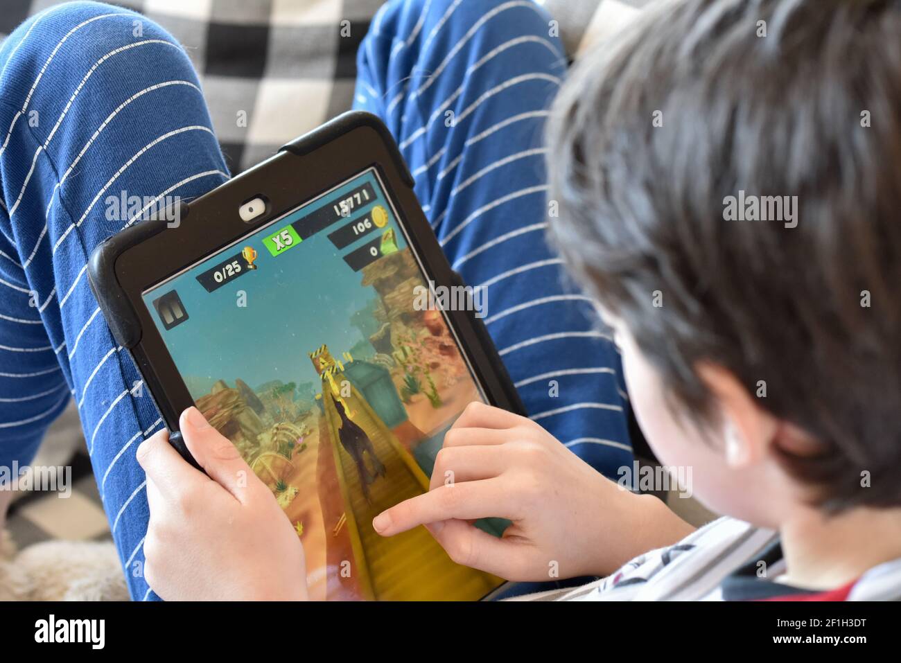 Boy playing on his tablet Stock Photo - Alamy