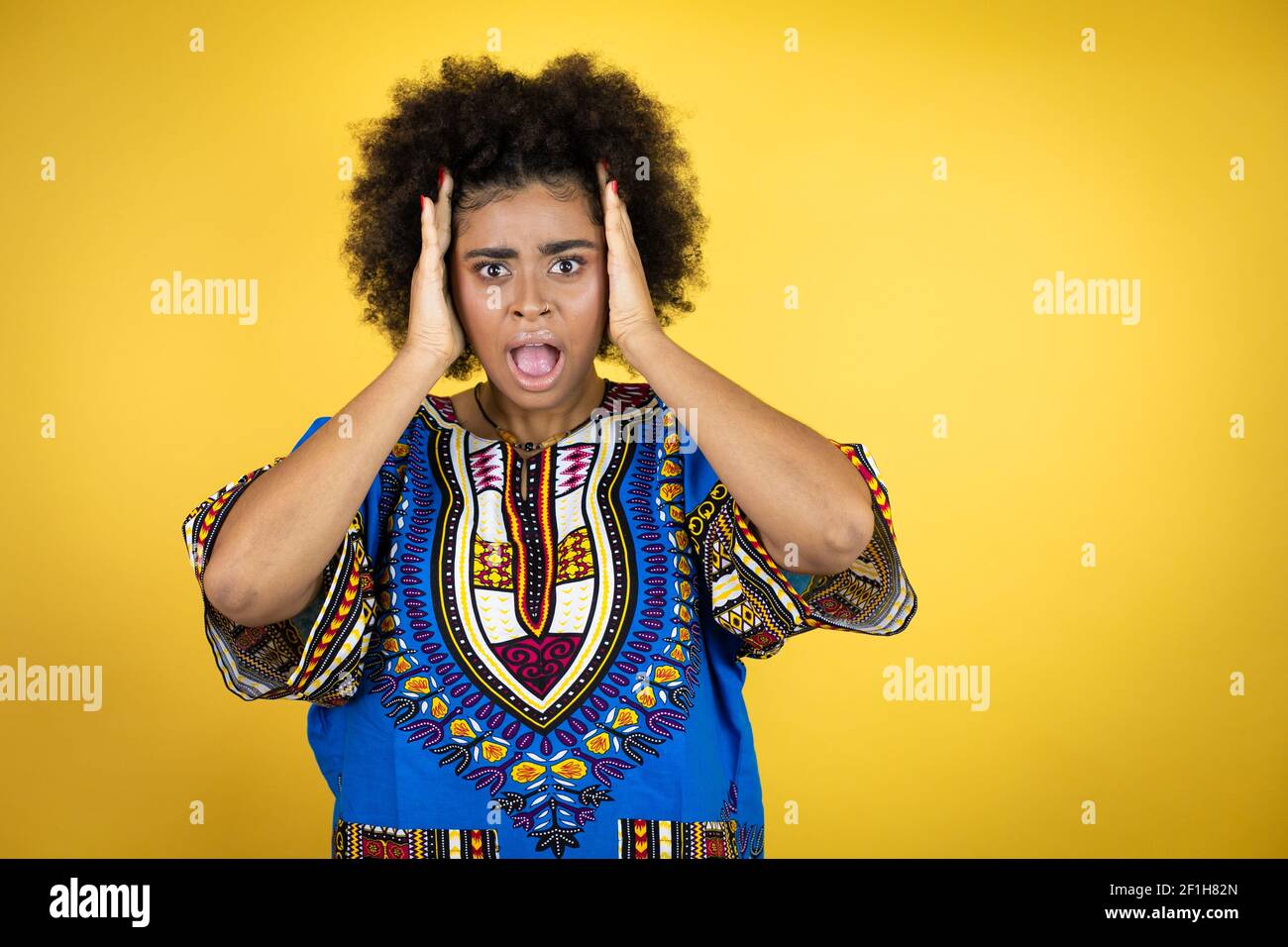 African american woman wearing african clothing over yellow background ...