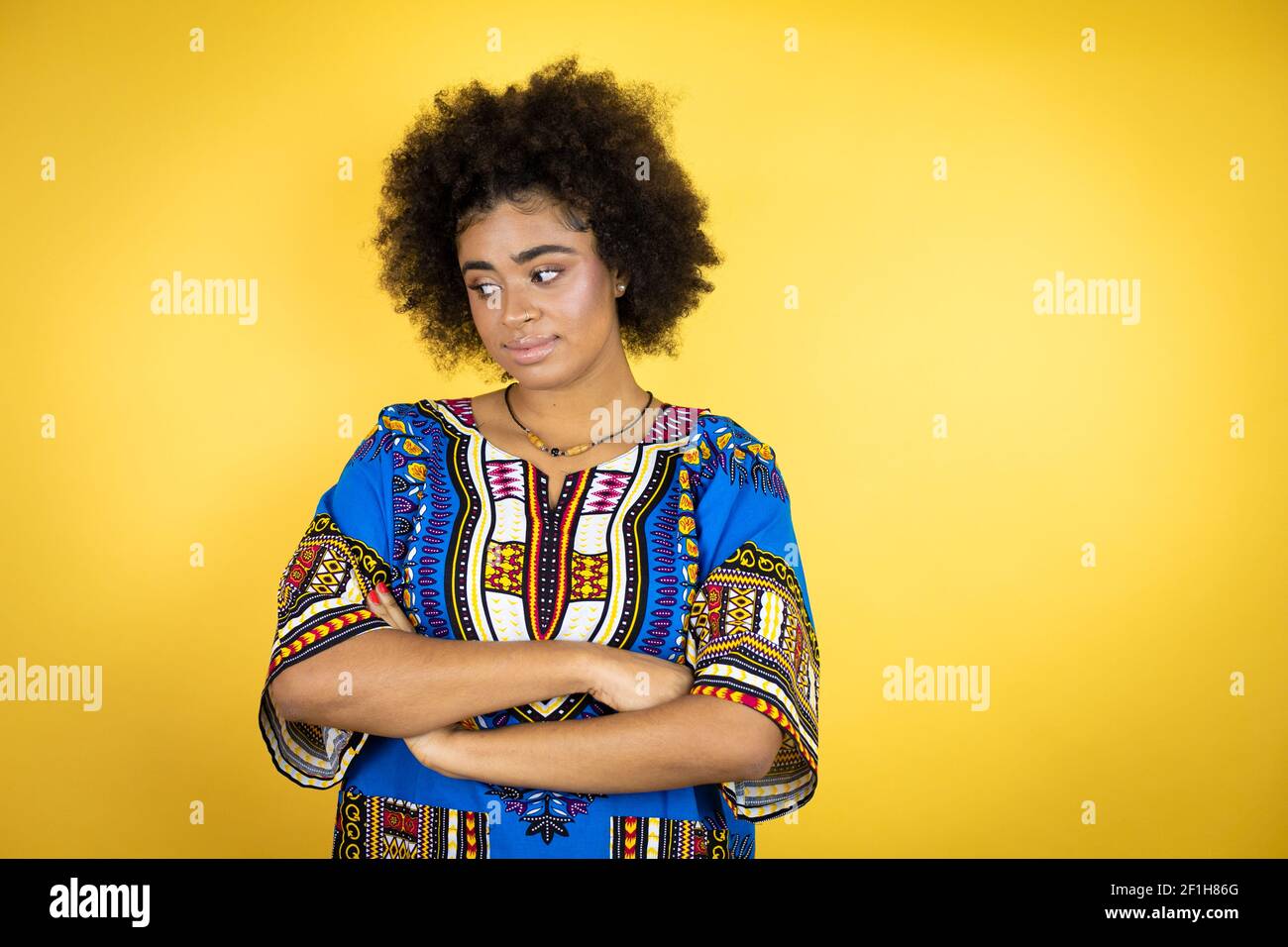 African american woman wearing african clothing over yellow background ...
