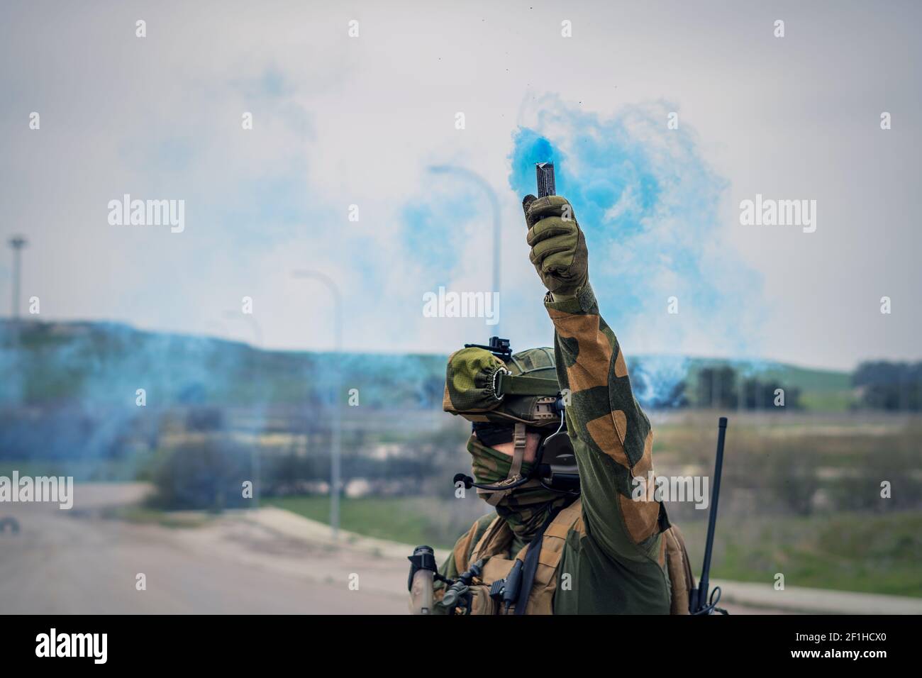 A special forces soldier holding a blue smoke bomb Stock Photo - Alamy
