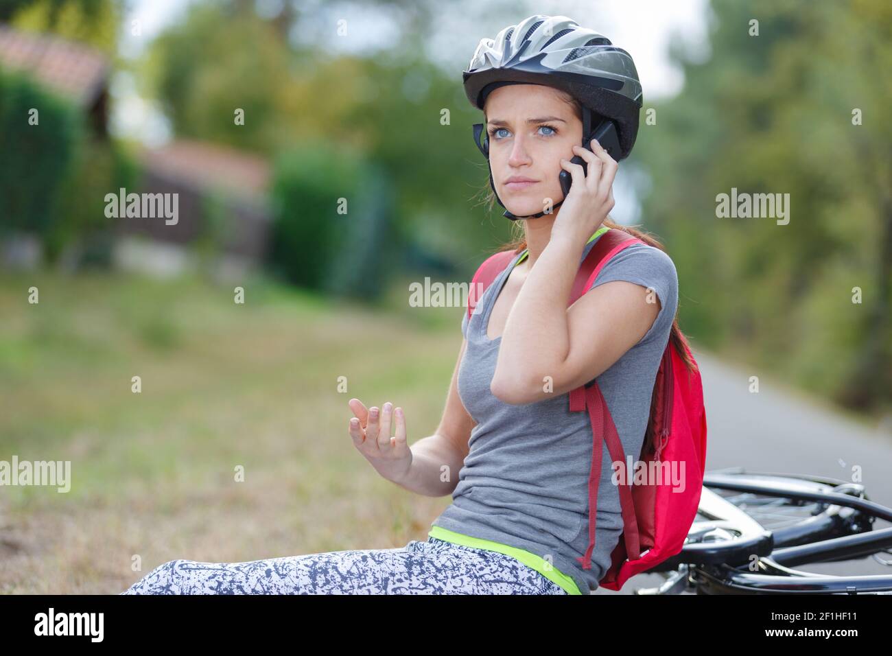 worried woman calling for help falling from bicycle Stock Photo - Alamy