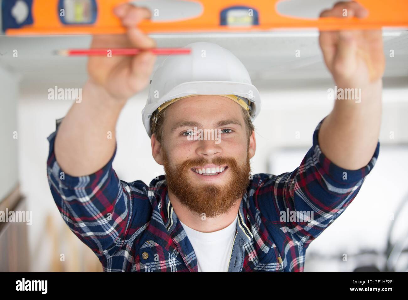 happy man taking measures with spirit level Stock Photo - Alamy