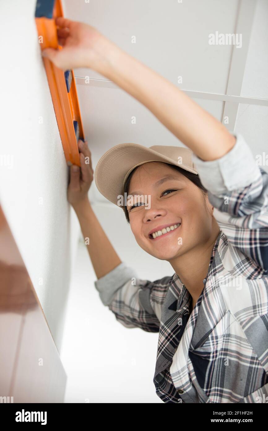 young woman measuring window level Stock Photo - Alamy