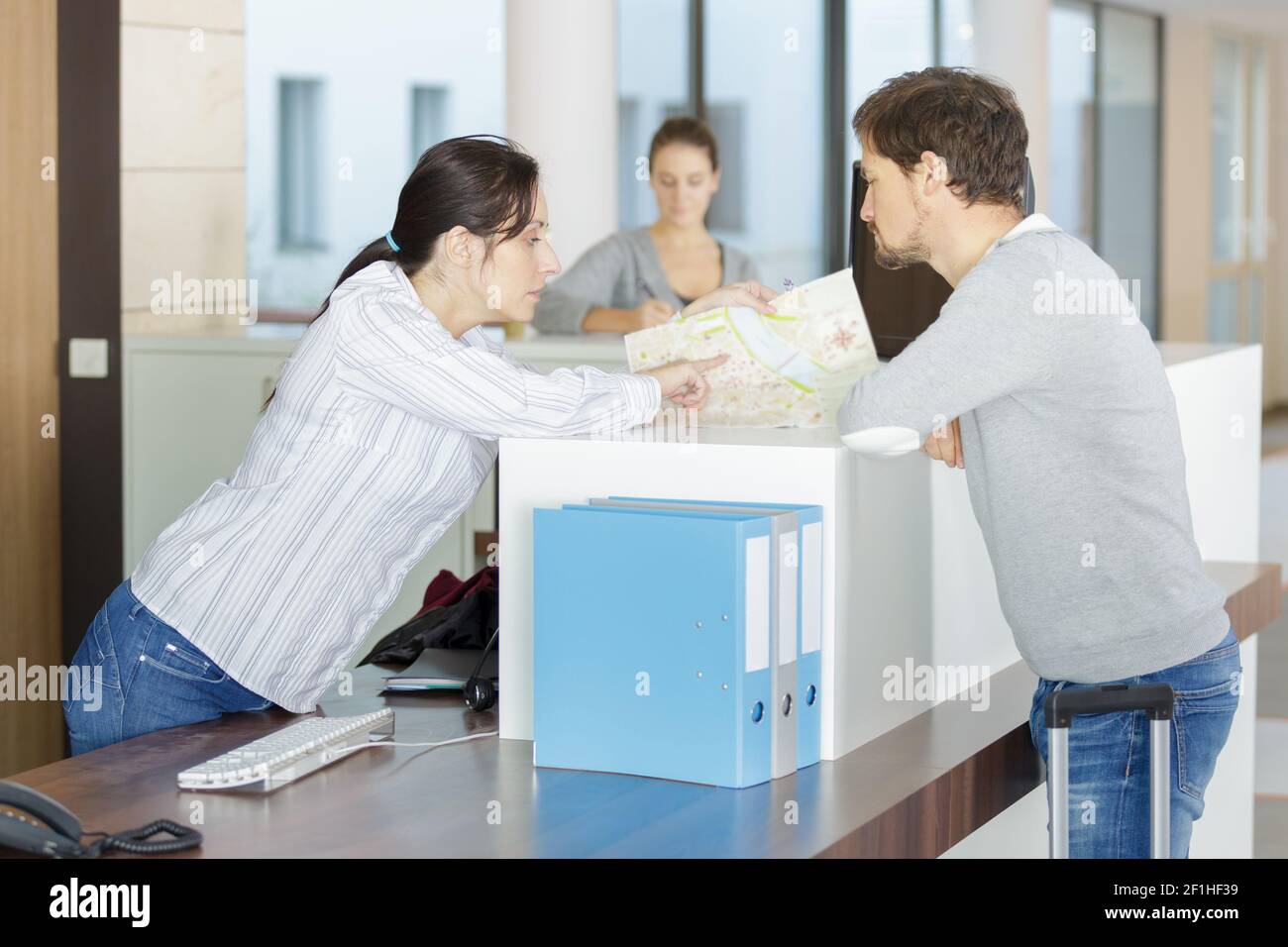 receptionist showing plan to her patient Stock Photo - Alamy
