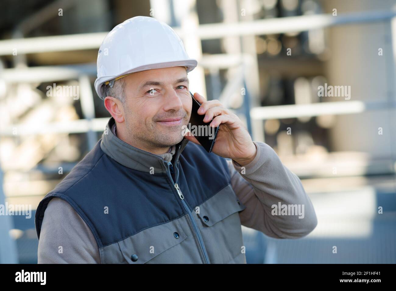 happy man engineer using mobile contact Stock Photo - Alamy