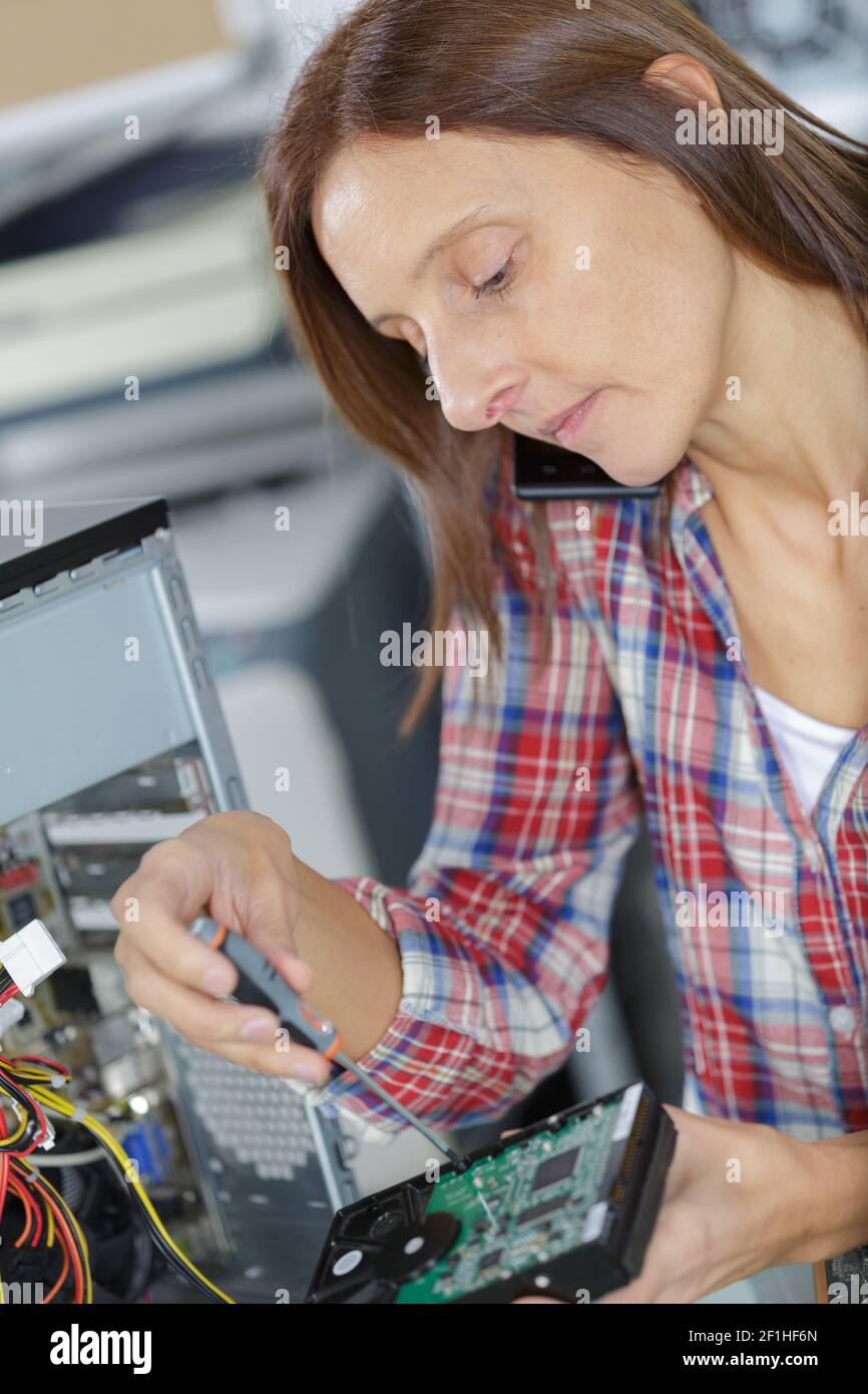woman fixing broken computer indoors Stock Photo - Alamy