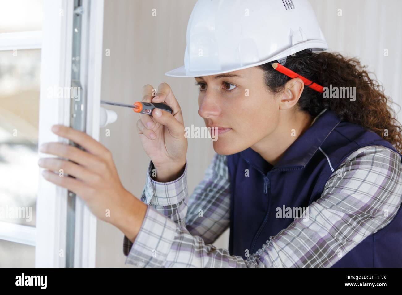 female builder fitting a window Stock Photo - Alamy