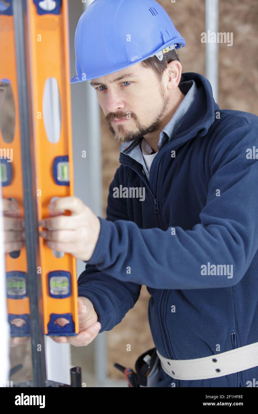 young worker is working with level Stock Photo - Alamy