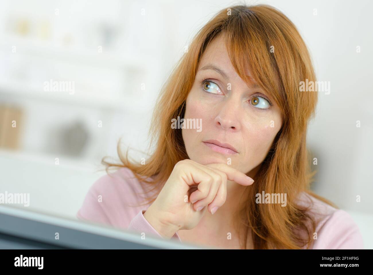 a thinking woman is worried Stock Photo - Alamy