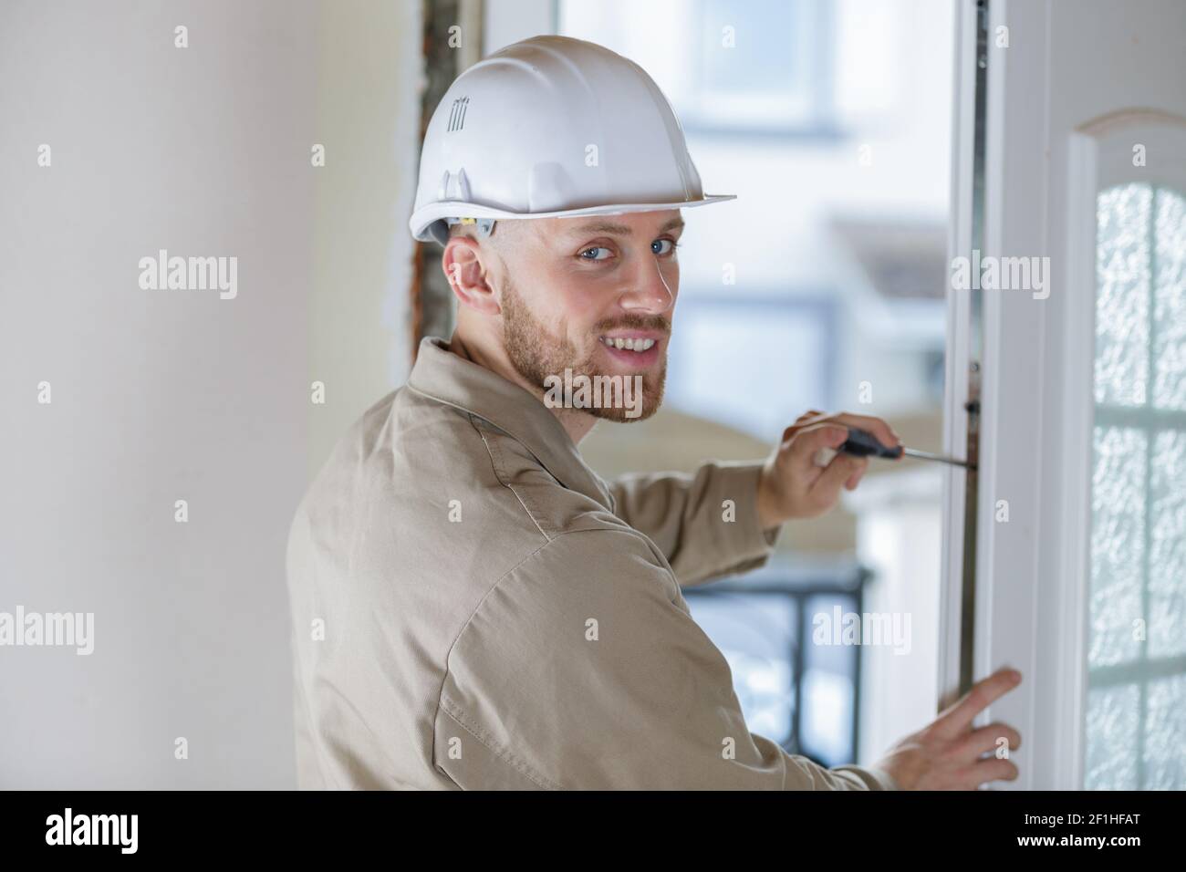 male worker during internal door installation Stock Photo - Alamy