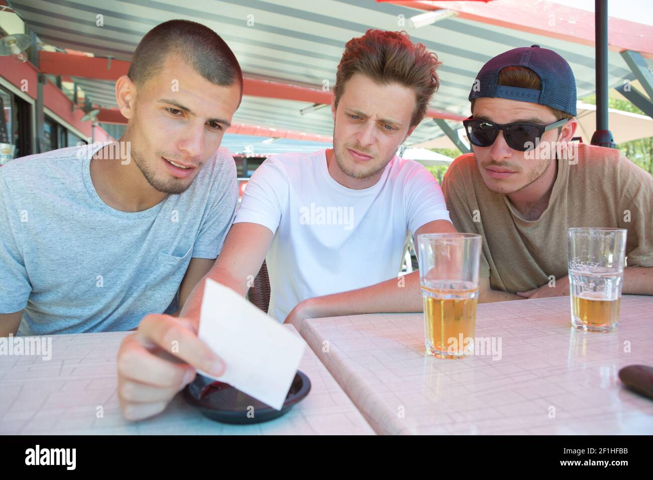three men having a drink outdoors Stock Photo - Alamy