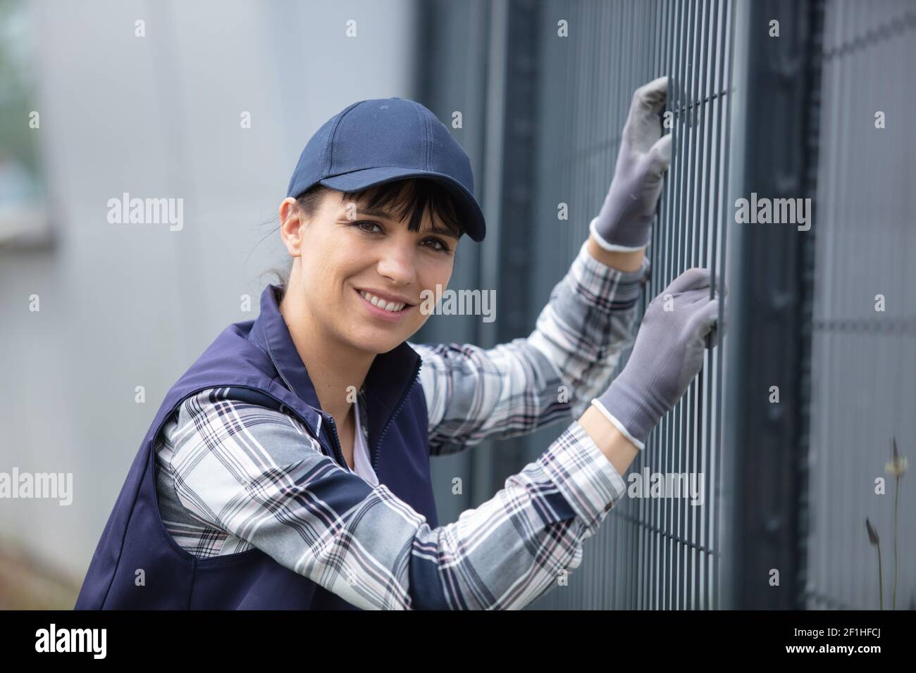 happy female builder setting up a fence Stock Photo - Alamy