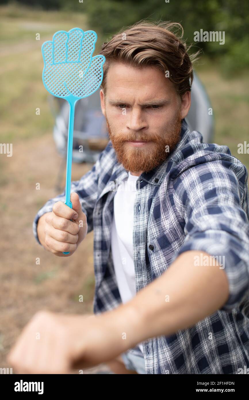 hitting a fly or a bug with flyswatter Stock Photo - Alamy