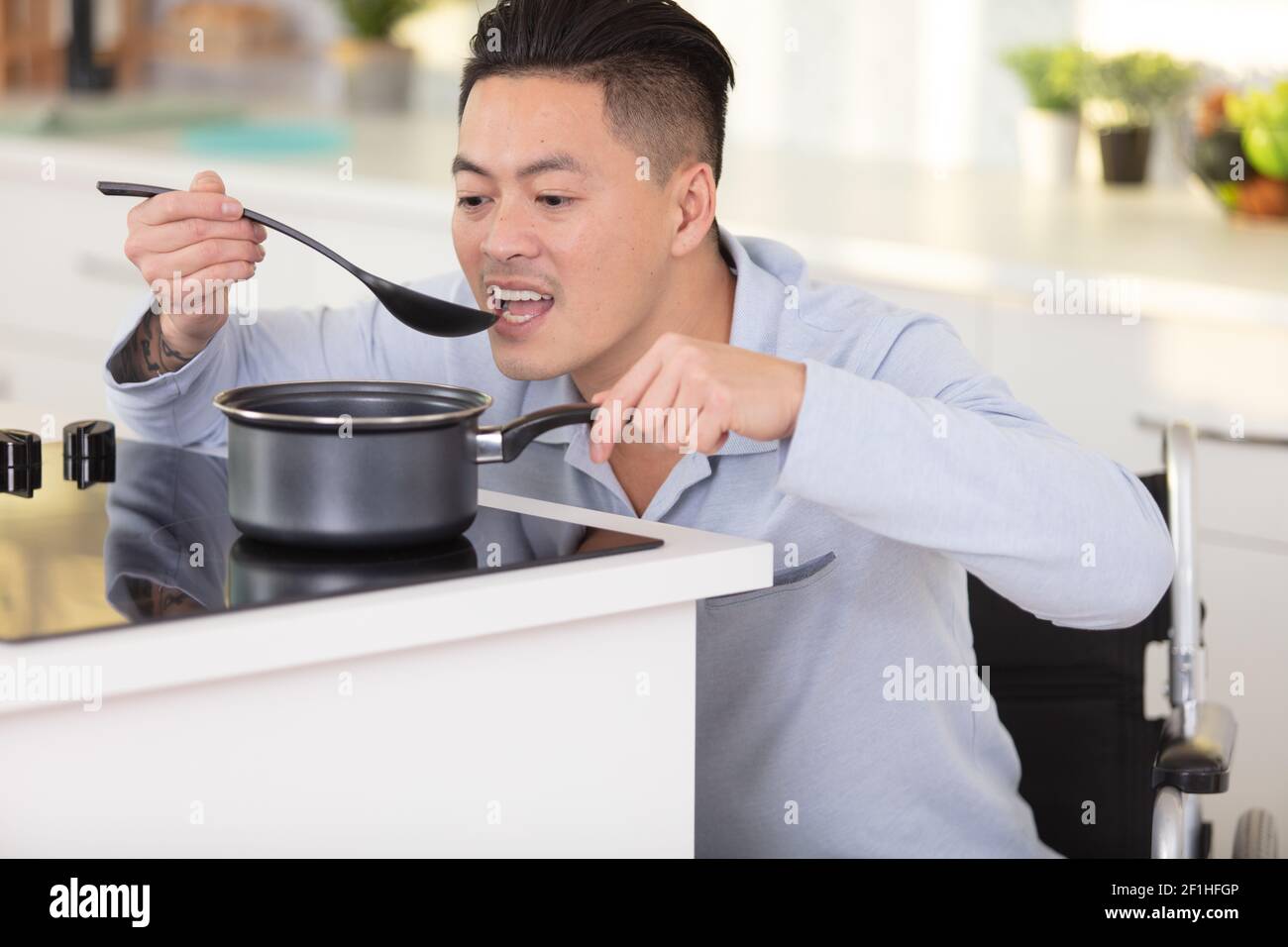 disabled young man in wheelchair preparing dinner in the kitchen Stock ...