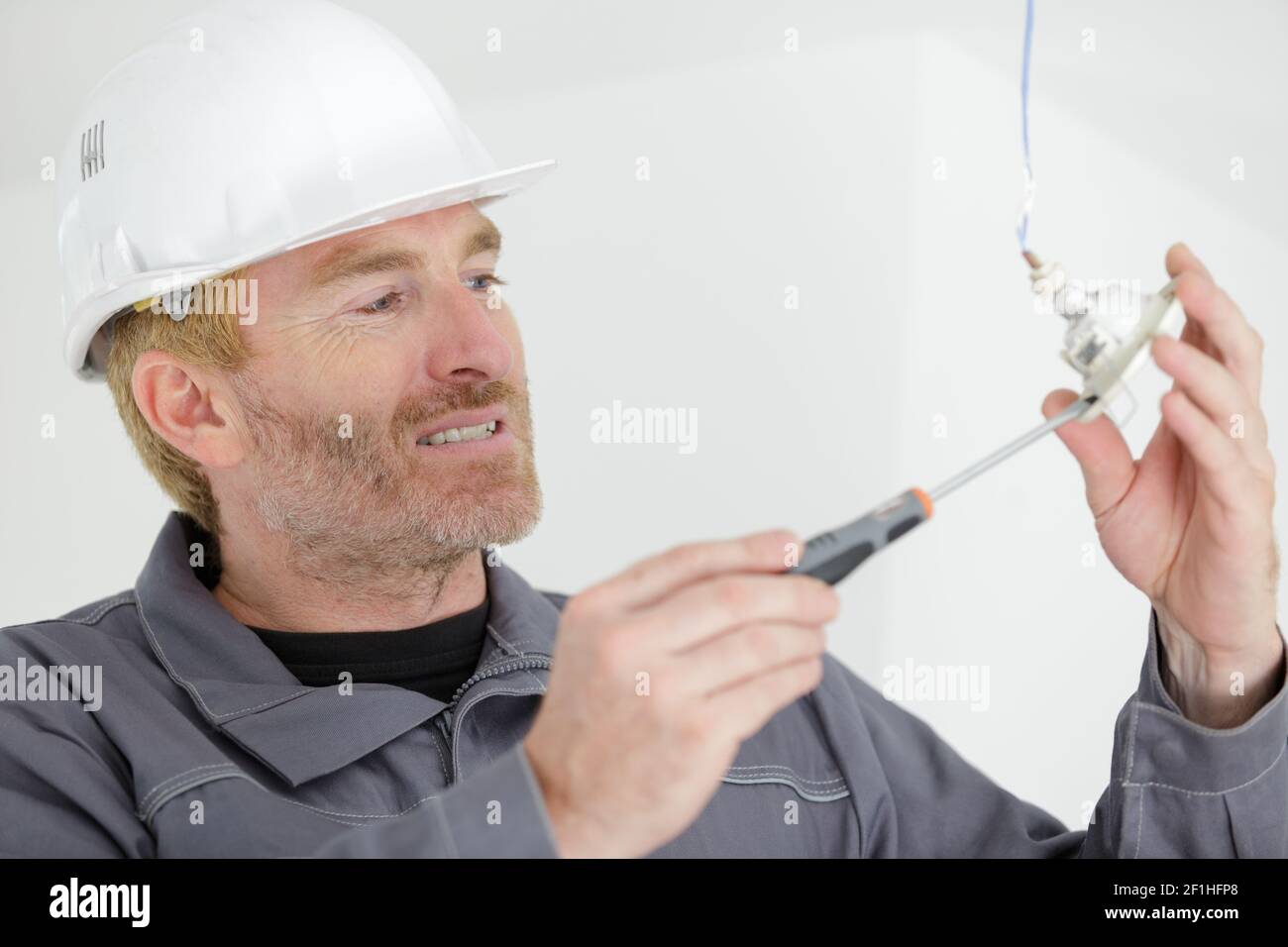 picture of male electrician installing hanging light Stock Photo - Alamy