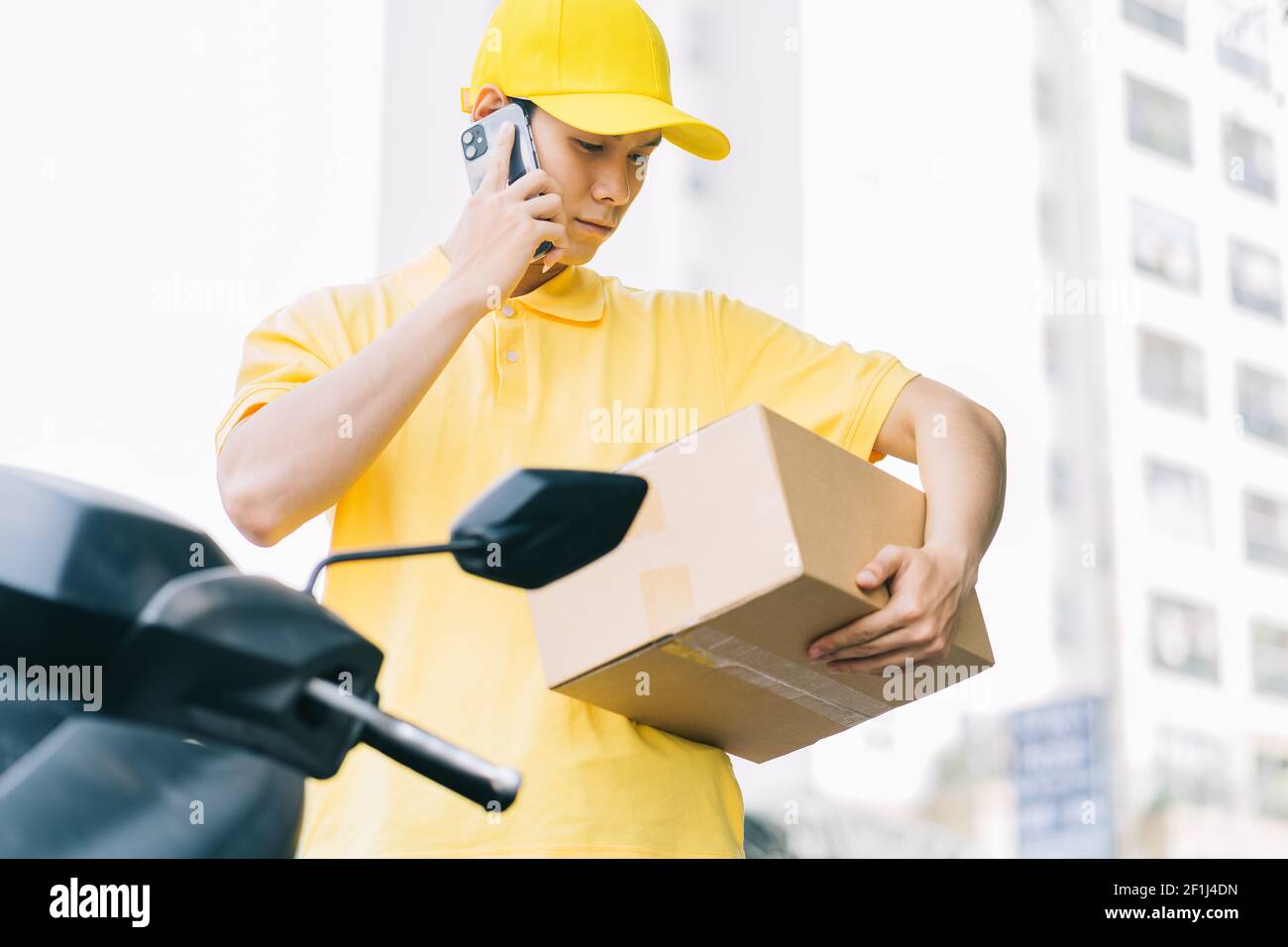 Asian shipper is calling the customer to get the goods Stock Photo - Alamy
