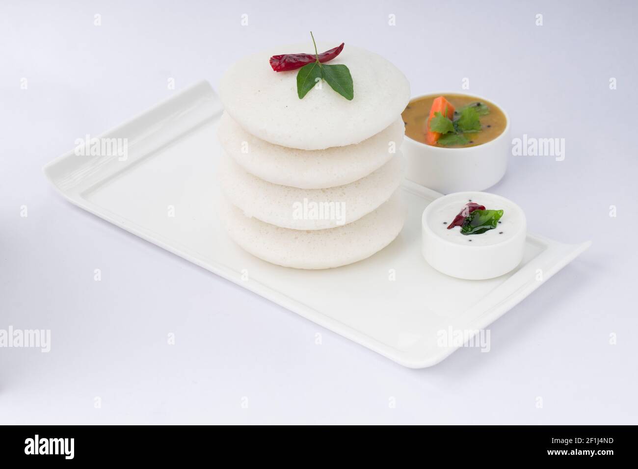 Idly or Idli, south indian main breakfast item garnished with red dry ...