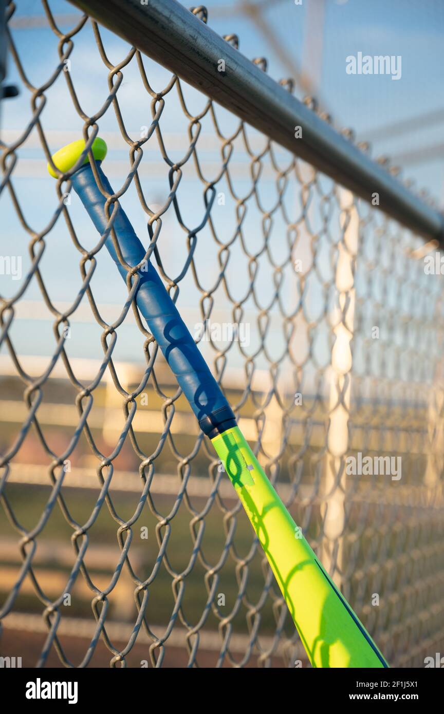 T-ball baseball bat hanging on dugout chainlink fence Stock Photo - Alamy