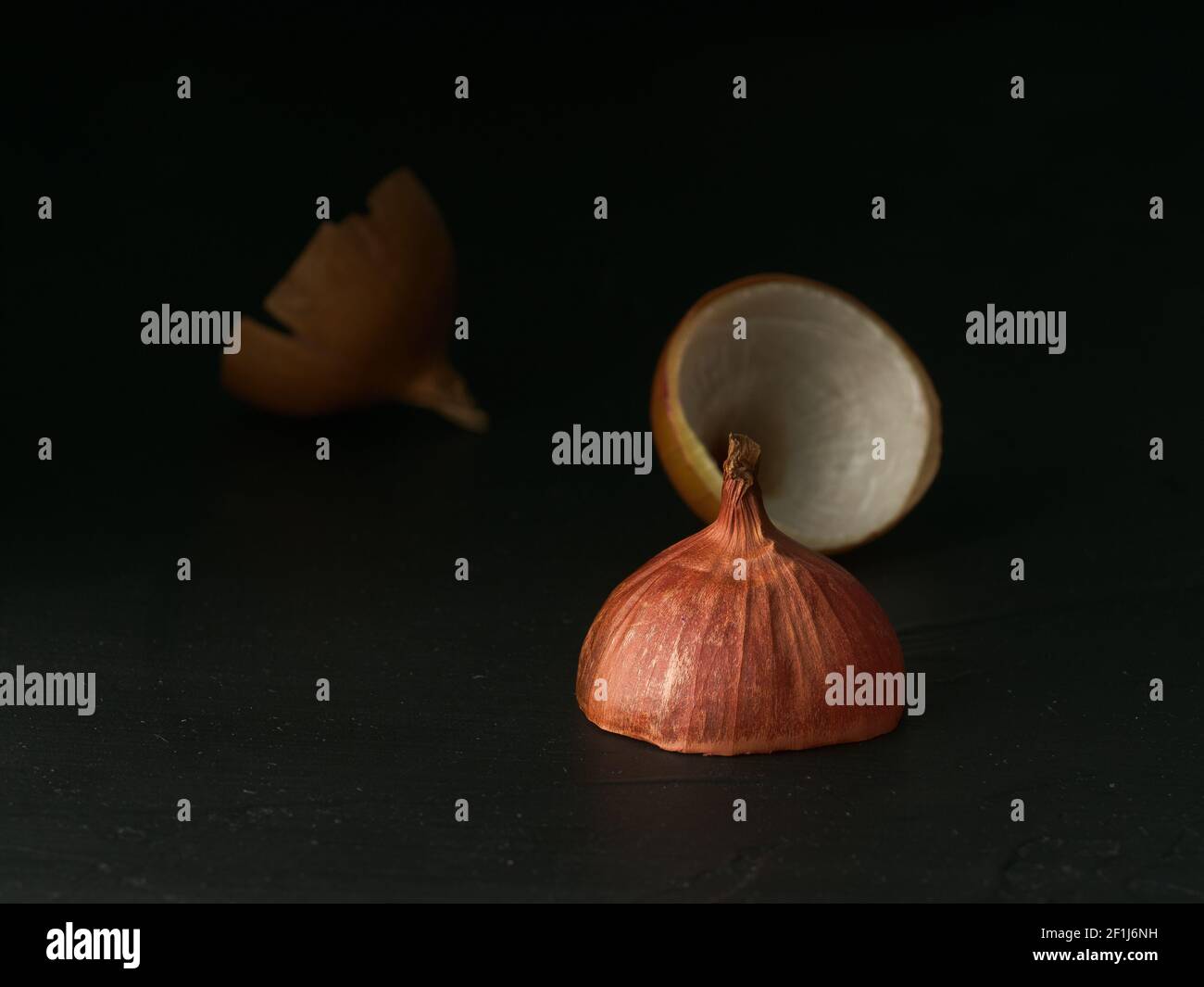 Three half parts of onion husk. Art composition close-up. Low key, dark ...