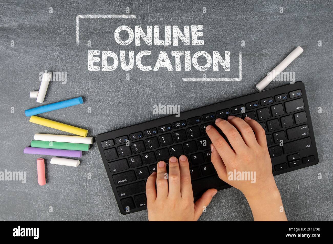 ONLINE EDUCATION. Computer keyboard on a gray chalk board background ...