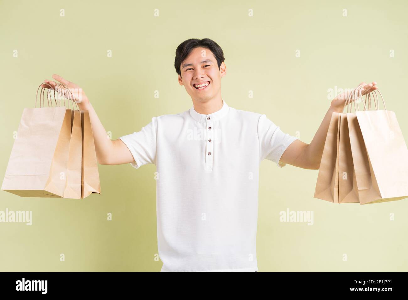 The handsome Asian man is holding paper bags in his hand Stock Photo ...