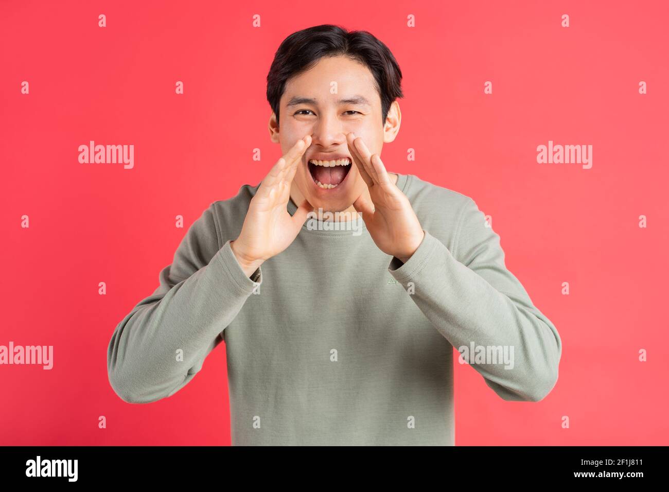 A Photo Of A Handsome Asian Man Covering His Mouth With His Hands