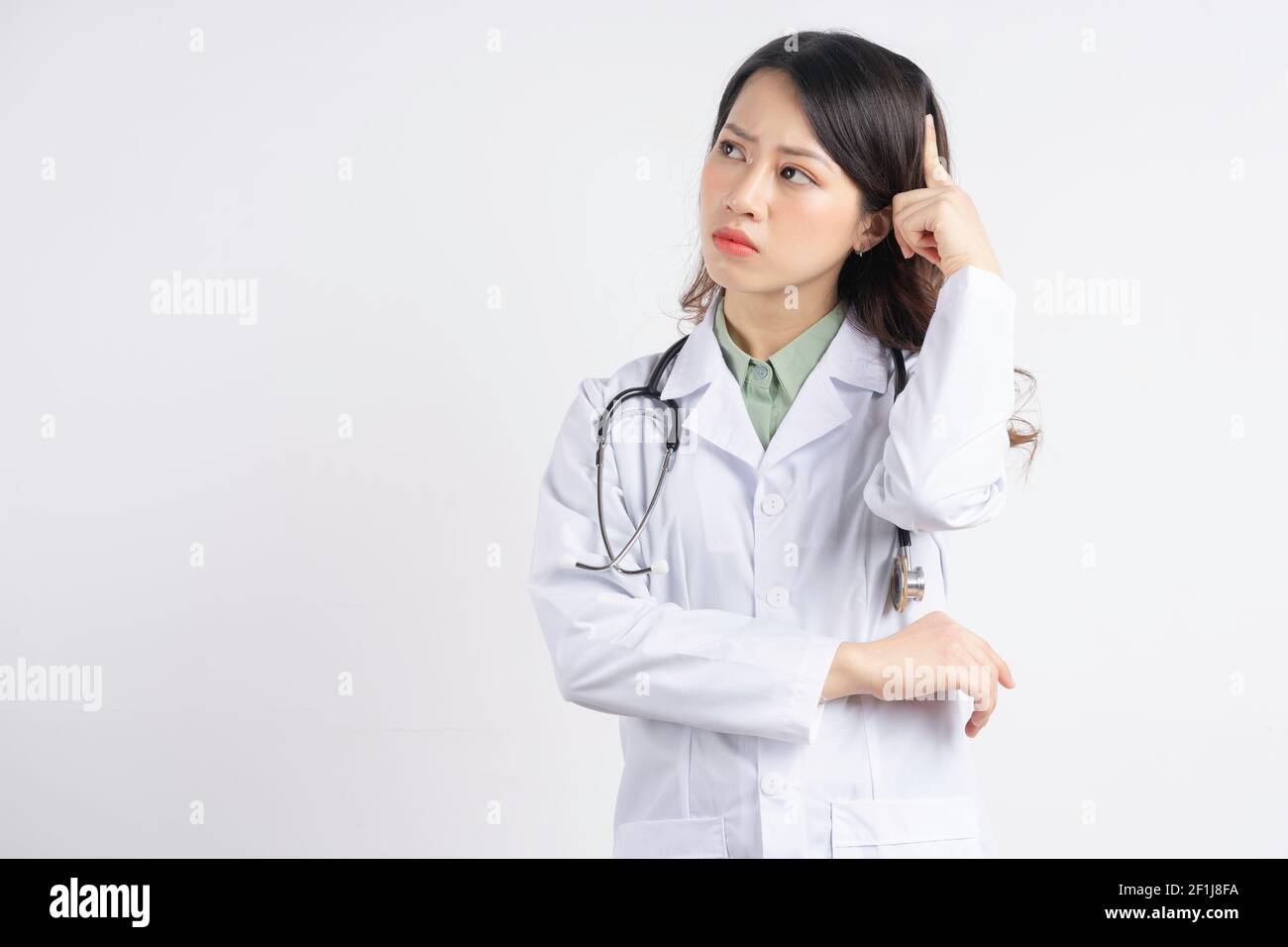 Portrait of an Asian female doctor scratching her head in thought Stock ...