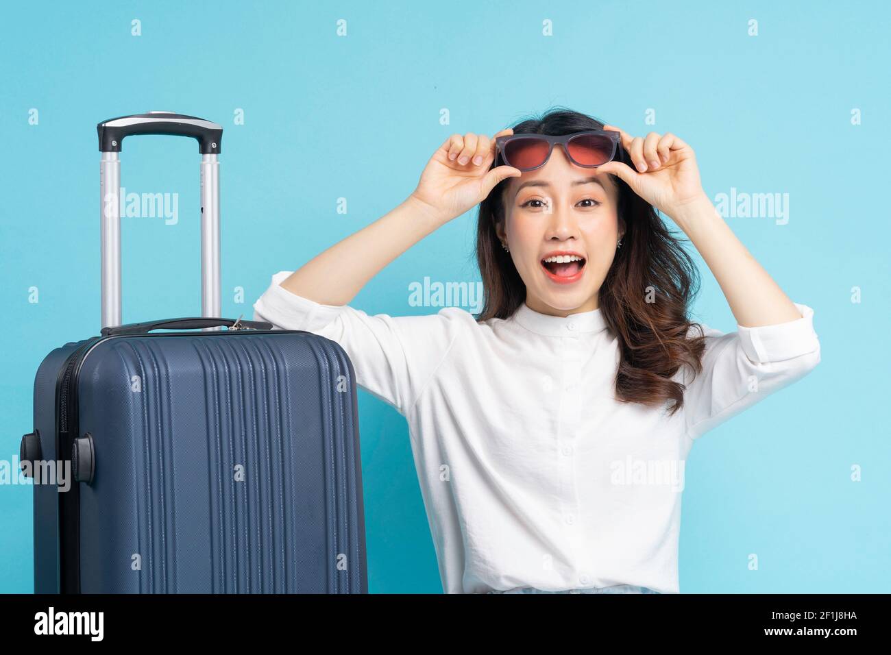 Beautiful Asian woman sitting posing beside suitcase and preparing for ...