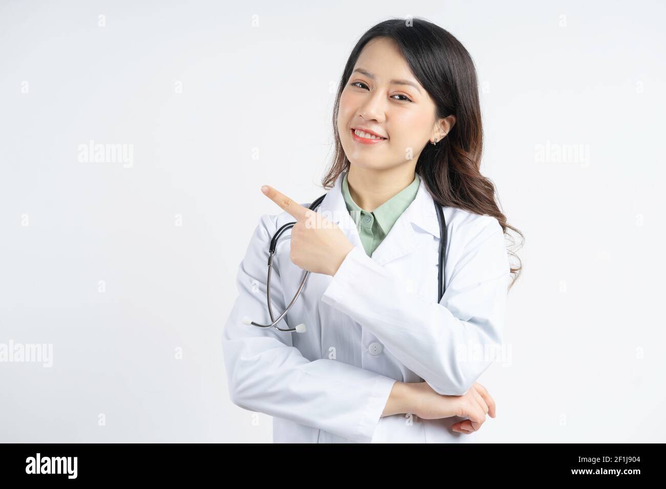 Portrait of an Asian female doctor with a cheerful face pointing ...
