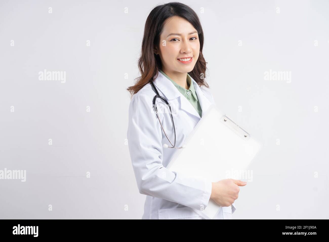 Portrait of asian female doctor standing smiling on white background ...